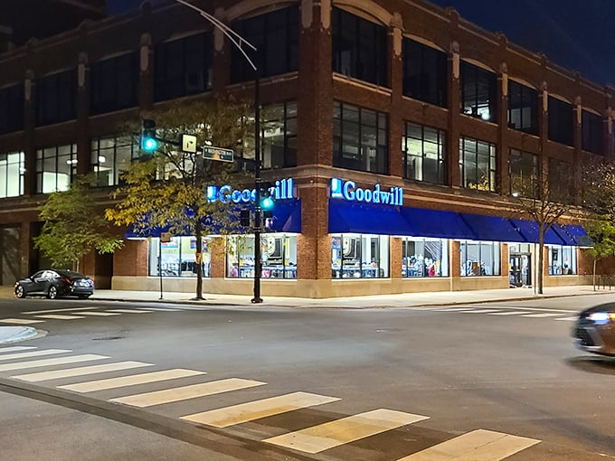 Night falls but the treasure hunt continues, Goodwill's blue glow illuminating the corner like a lighthouse for bargain seekers.