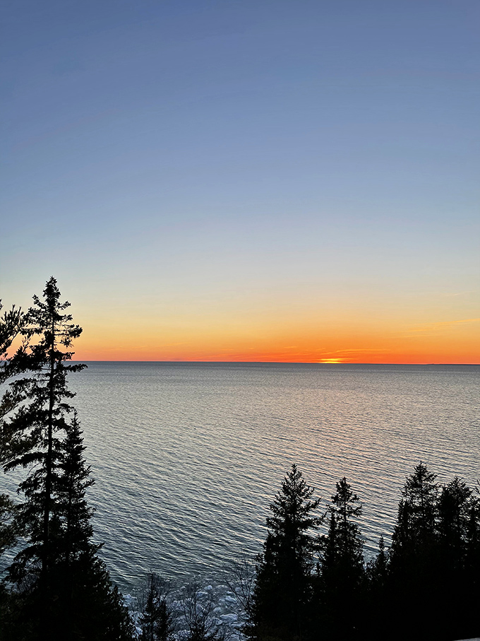 As day ends over Lake Michigan, the water ignites with sunset colors, proving that even the finale of a Tunnel of Trees day doesn't disappoint.