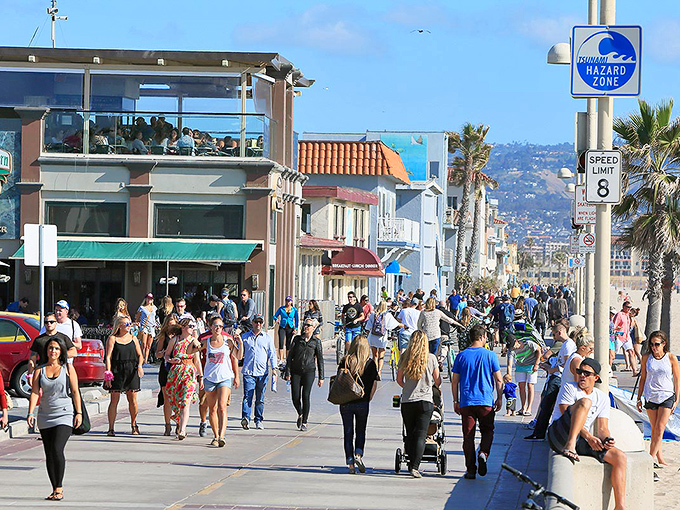 The Strand buzzes with humanity on perfect afternoons, a parade of sun-worshippers proving that sidewalks can be legitimate tourist attractions.