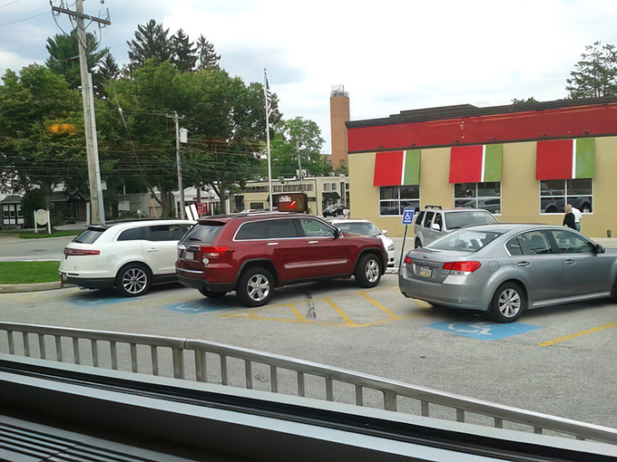 The view from inside captures life in motion&mdash;cars coming and going in the parking lot, a reminder that a great diner is always at the center of community life.