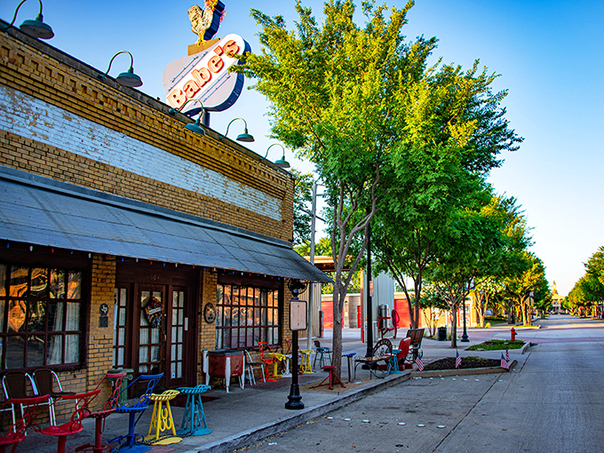 That neon sign isn't just decoration&mdash;it's a beacon of hope for the crispy-chicken deprived. Classic brick storefront with colorful chairs just waiting for you.