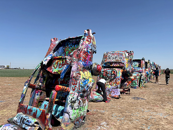 Colorful Cadillacs standing at attention! These spray-painted relics create a surreal automotive graveyard in the vast Texas plains.