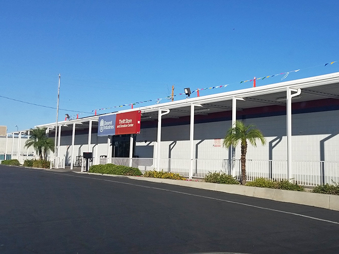 The Deseret Industries building stands like a treasure chest under the Arizona sky, promising adventures in thrifting behind its white walls.