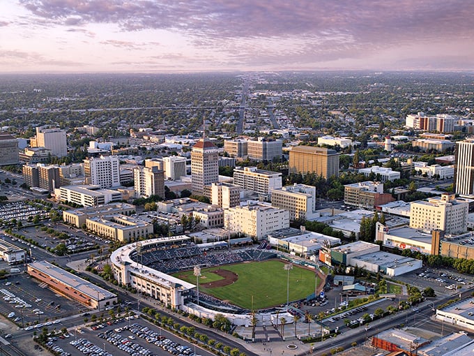 Fresno's downtown skyline glows at sunset, with the baseball stadium nestled among buildings like a diamond in an urban treasure chest.
