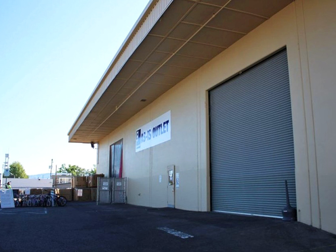 The unassuming exterior of Goodwill's As-Is Outlet - where treasure hunting begins with a roll of blue bins and ends with amazing bargains.