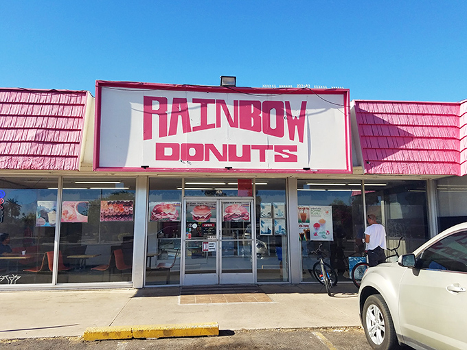 That iconic pink roof and bold "RAINBOW DONUTS" sign &ndash; like a beacon of fried dough happiness calling you home.