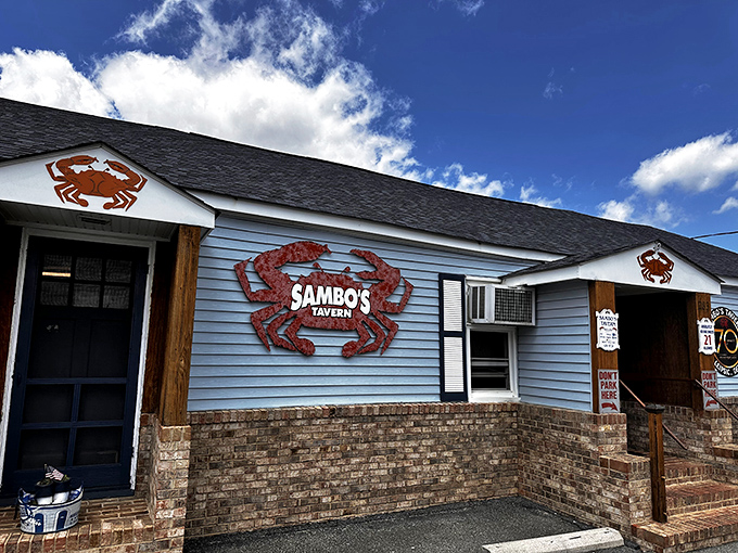The blue clapboard charm of Sambo's Tavern promises crab heaven. Those red crab signs aren't lying—seafood paradise awaits inside!