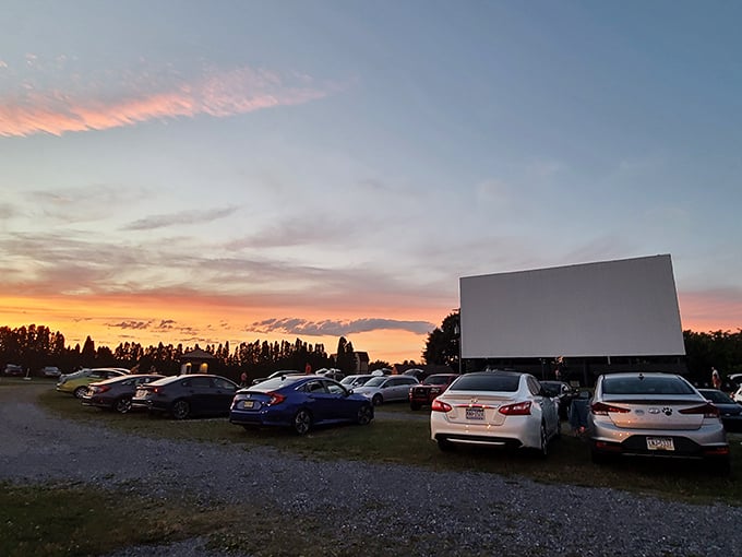 Sunset magic at the drive-in! Cars line up as the sky puts on its own show before the feature presentation begins.