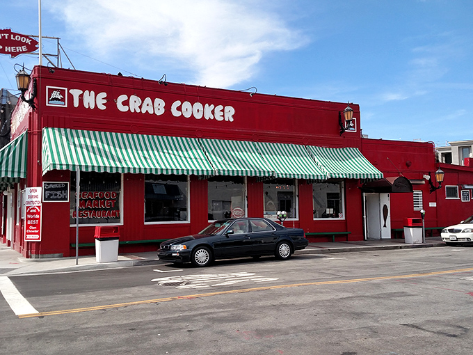 The Crab Cooker's iconic red building stands out like a seafood beacon. That green and white awning promises simple surroundings but extraordinary flavors inside!