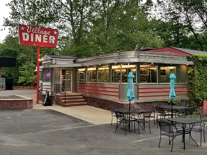 The Village Diner's classic red and silver exterior is like stepping into a Norman Rockwell painting where calories don't count and coffee refills are mandatory.