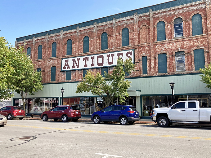 That "ANTIQUES" sign isn't just advertising&mdash;it's a siren call to treasure hunters. This brick beauty houses more stories than your grandpa after his third cup of coffee.