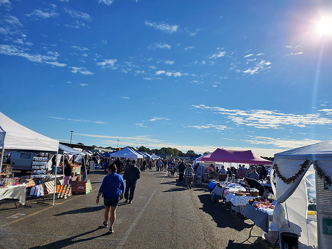 Blue skies and bargains ahead! Shoppers stroll between white tents, each one a portal to unexpected treasures.