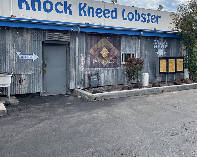 The "NOT HERE" sign points elsewhere, but trust me&mdash;this weathered blue-trimmed building is exactly where your seafood cravings need to be.