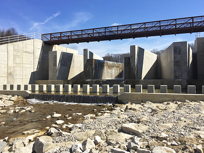 Modern art meets practical engineering at the dam structure, where geometric concrete forms create an unexpectedly photogenic industrial landscape.