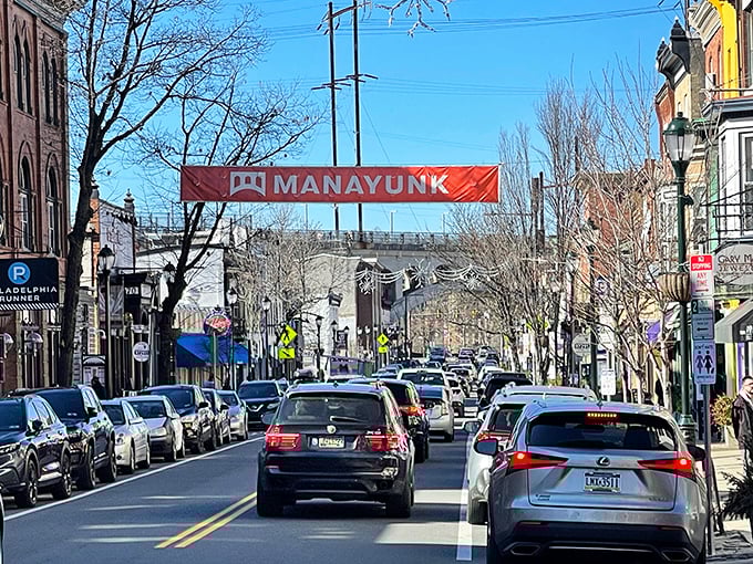 The iconic Manayunk banner welcomes visitors to Main Street, where cars line up for the privilege of experiencing this vibrant neighborhood. Urban energy with small-town soul.