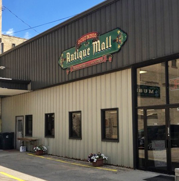 That vintage sign beckons like an old friend waving you over to share stories from decades past. Small flowers add a touch of welcome.
