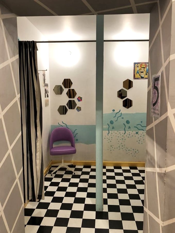 The fitting room alone is worth the visit—checkerboard floors, aquatic murals, and a purple chair that looks straight out of a Saved by the Bell set.