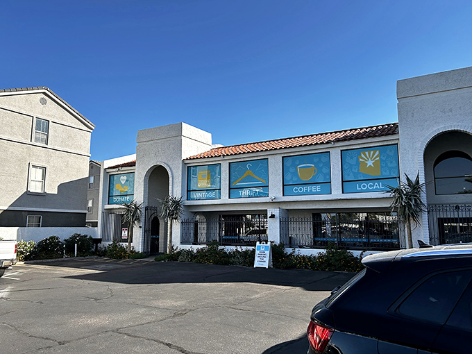 Under the clear Arizona sky, this white building with its distinctive blue signage stands as a beacon for thrift enthusiasts and coffee lovers alike.