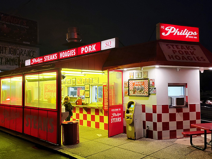 Night falls, but Philip's neon glow promises salvation for late-night cravings. The red and white checkerboard pattern is a culinary chess move.