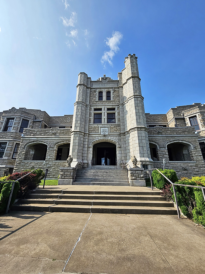 The castle's imposing facade reaches skyward with its distinctive turrets, creating a silhouette that seems delightfully out of place against Missouri's blue skies. 