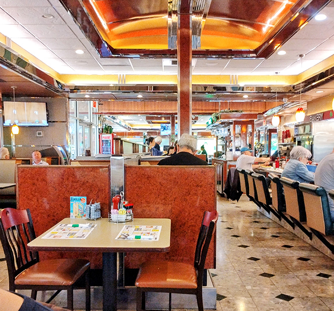 
Sliding into these burnished orange booths feels like time travel. The warm wood accents and checkered floor create that perfect nostalgic diner atmosphere we all crave.