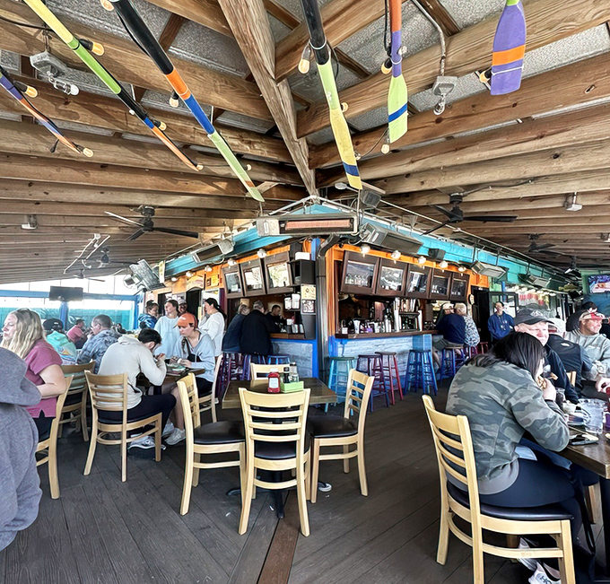 Where colorful oars hang from wooden beams like trophies of nautical conquests, and every seat promises a front-row view of seafood nirvana.