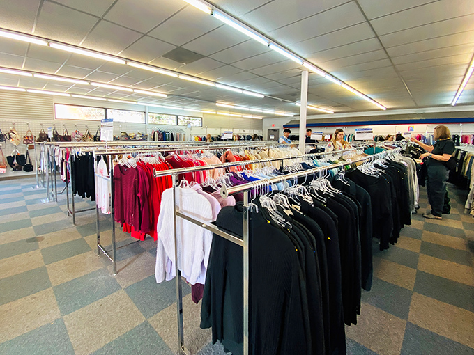 Color-coded clothing racks stretch toward fluorescent horizons, a textile galaxy where shoppers navigate through fashion's past and present.