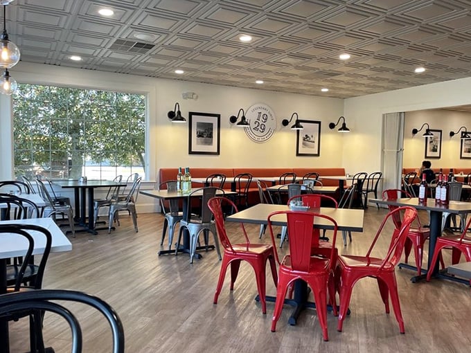 Red chairs pop against neutral tones in this thoughtfully designed dining space, where conversations flow as freely as the coffee refills.