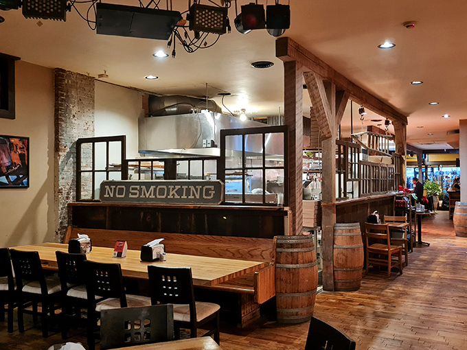 Exposed brick walls meet wooden barrels and warm lighting inside, creating that perfect "third place" atmosphere where conversations flow as freely as the craft beer.