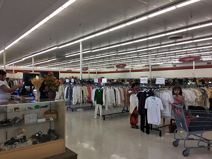 Endless racks stretch toward retail infinity under fluorescent lights. The organized chaos of City Thrift's interior promises adventures in every aisle.