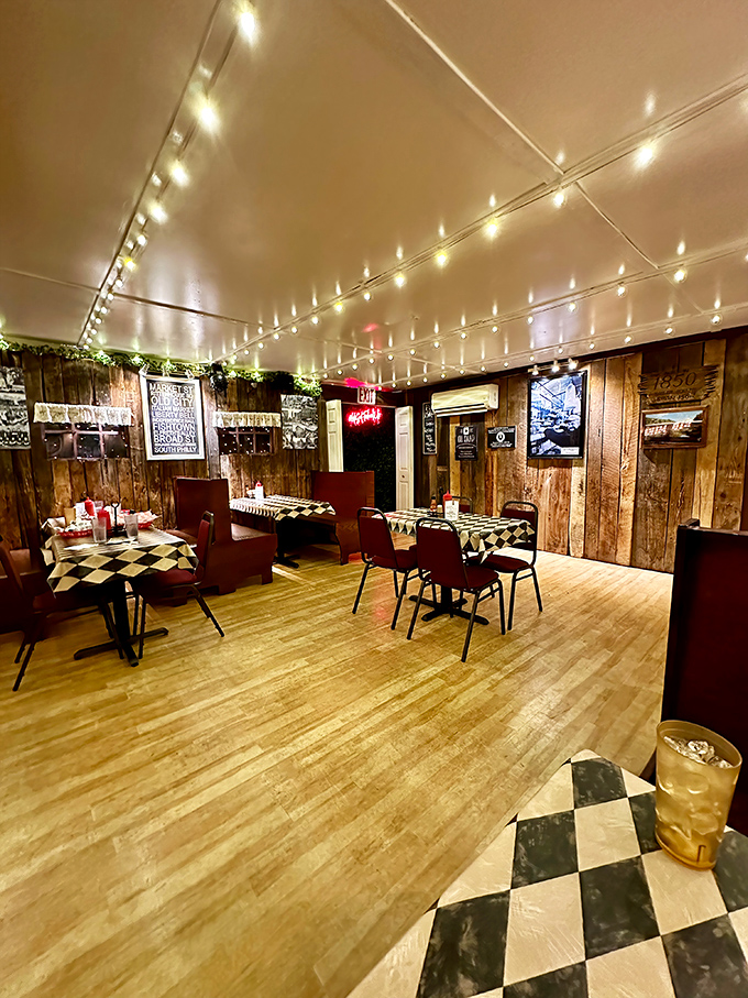 String lights dance across wooden walls, creating the perfect ambiance for sandwich bliss. The checkered tablecloths whisper, "Sit down, stay awhile."