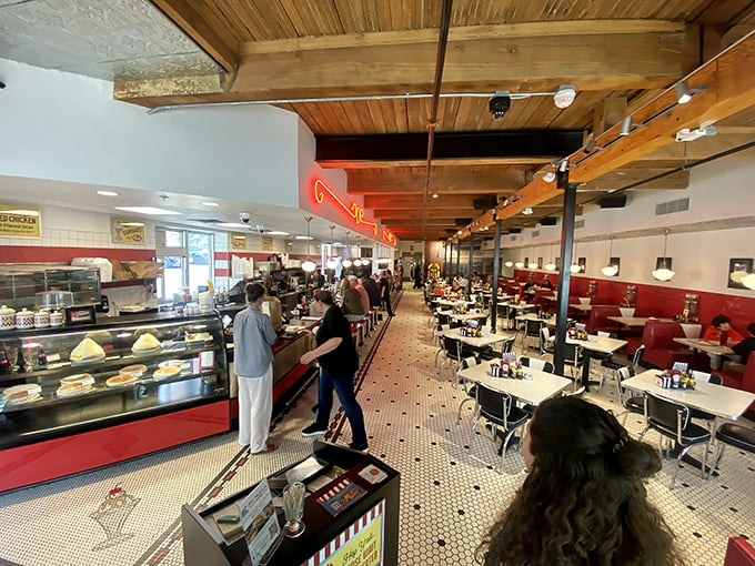 Classic black and white tiles, red booths, and wooden beams create that perfect diner atmosphere where calories don't count and conversations flow like milkshakes.