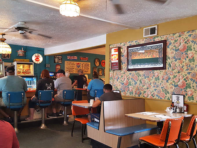 Step inside and you're transported to diner nirvana&mdash;floral wallpaper, blue counter stools, and orange chairs create that perfect "grandma's kitchen meets American classic" vibe we all crave. 