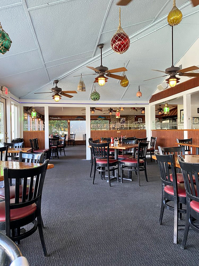 Colorful glass floats dangle from the ceiling like underwater Christmas ornaments, creating the perfect nautical atmosphere for seafood indulgence.