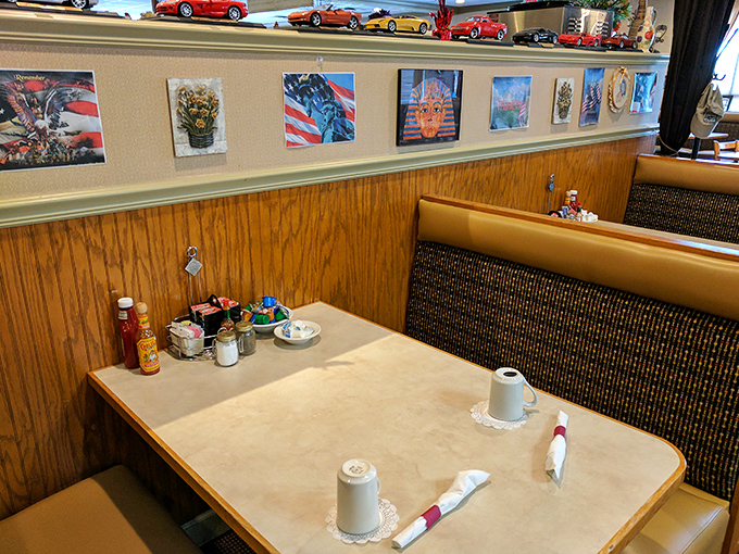 Classic diner comfort with model cars lining the shelves—your cozy booth awaits while coffee mugs stand ready for refills.