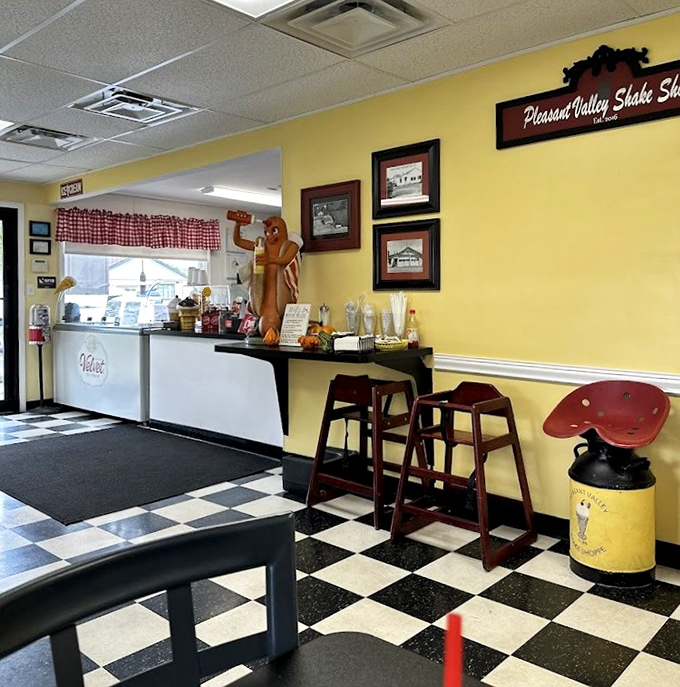 Classic black and white checkered floors meet sunny yellow walls, while a friendly hot dog mascot stands guard over ice cream treasures.