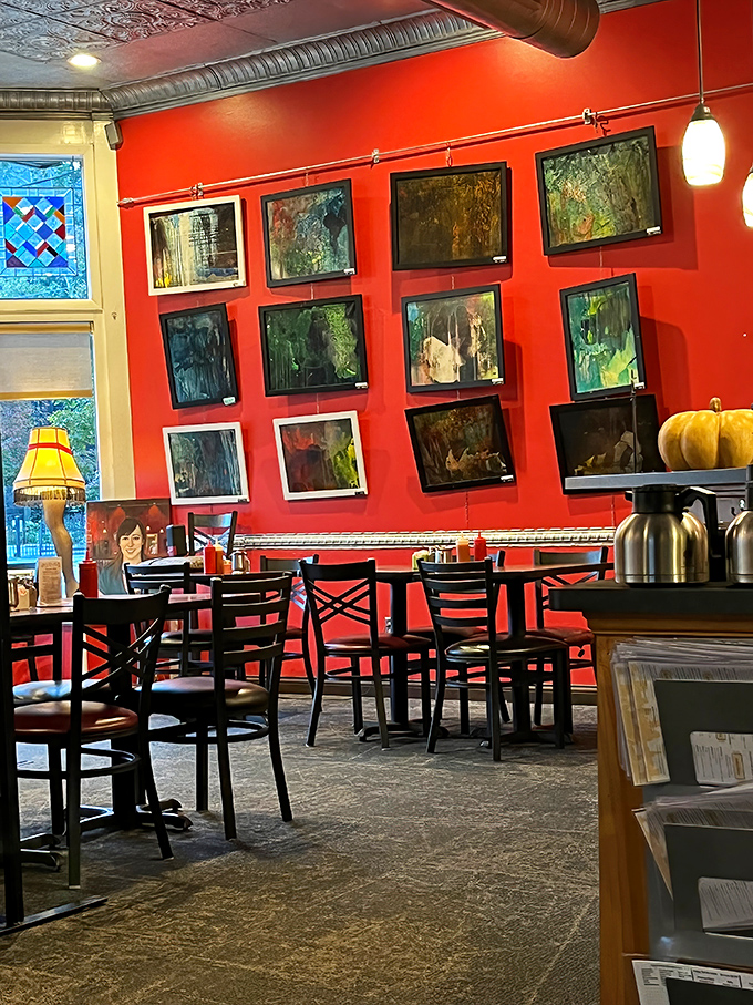 Vibrant red walls adorned with local artwork create the perfect backdrop for morning conversations and coffee refills.