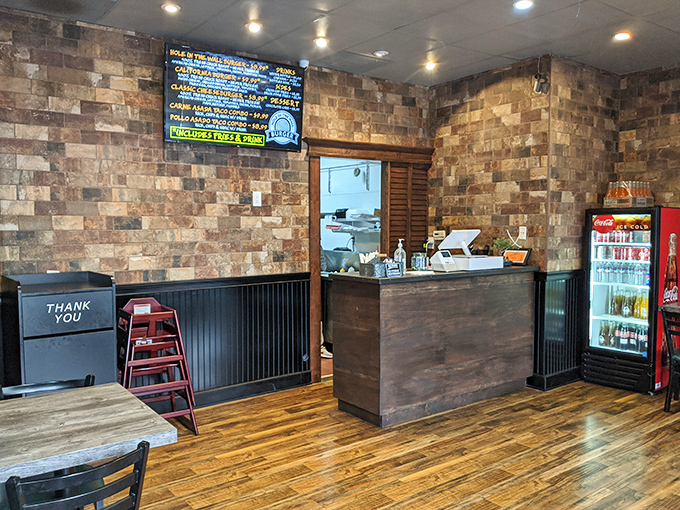 Rustic brick walls meet warm wooden floors in this cozy burger sanctuary. The minimalist design speaks volumes: all attention belongs on the food.