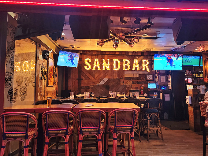 The glowing SANDBAR sign acts as a beacon to hungry travelers, promising good times and even better food in this wood-paneled paradise.