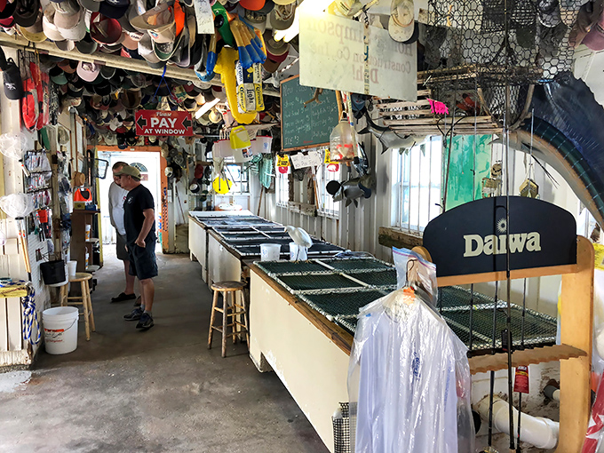 Inside the bait shop, where fishing dreams and lunch orders coexist in perfect harmony. Even the hats on the ceiling have stories to tell.