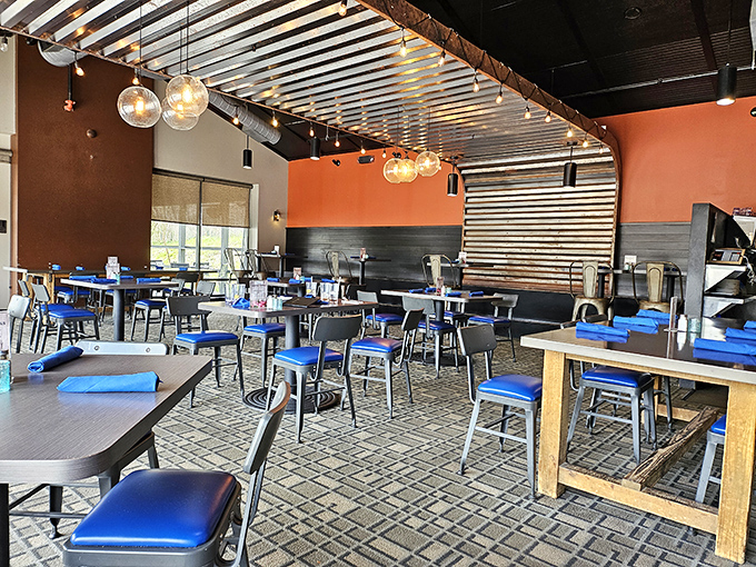 Industrial-chic meets cozy comfort inside Station 101, where orange walls and blue chairs create an atmosphere that says "stay awhile" without trying too hard.