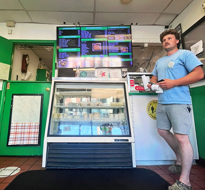 Behind the counter, the digital menu board showcases Walt's legendary offerings while the display case tempts with sides ready for pairing.