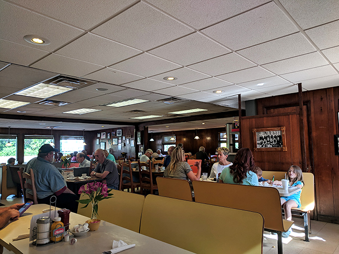 Inside Hyde's, yellow booths cradle generations of diners while wood paneling and family photos create that perfect "welcome home" atmosphere you can't manufacture.