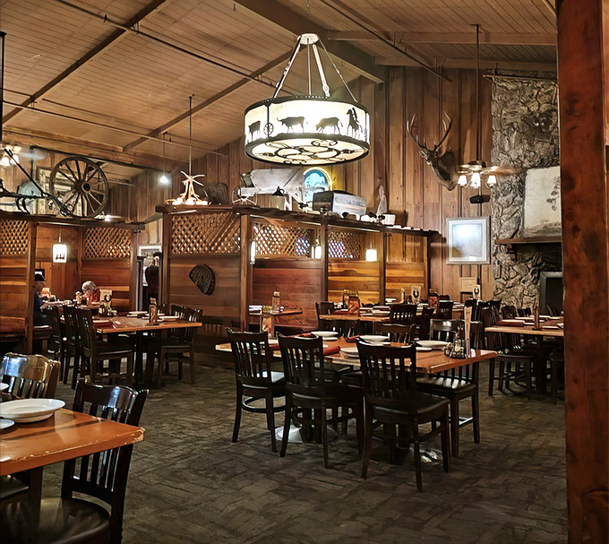 Rustic wooden beams, wagon wheel chandeliers, and mounted trophies create the perfect backdrop for serious steak consumption.