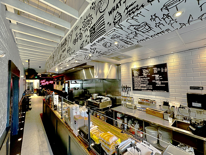 The open kitchen concept lets you watch culinary magic happen beneath a ceiling decorated with playful doodles &ndash; hot dog artistry in full view.