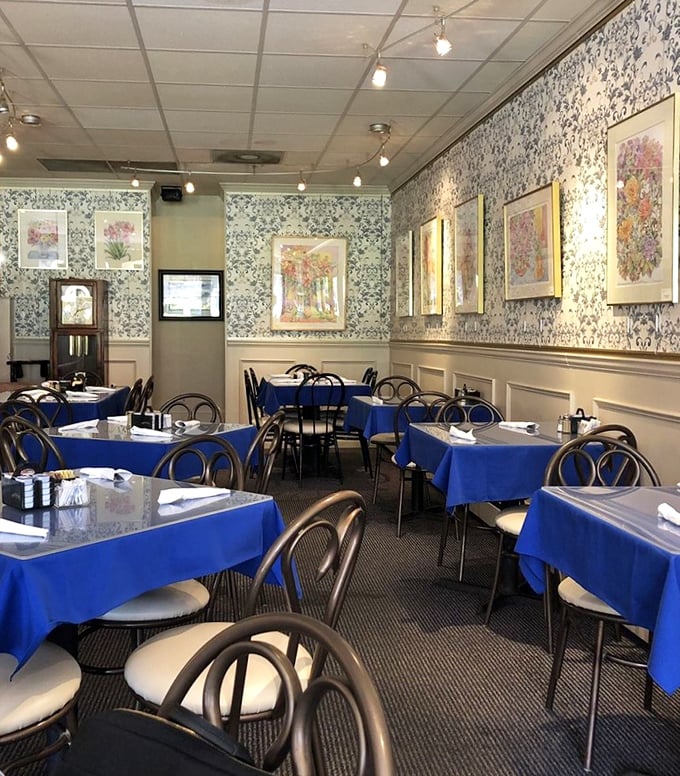 Blue tablecloths and floral wallpaper create that perfect "grandma's dining room" vibe&mdash;if grandma happened to be a breakfast wizard with a PhD in comfort. 
