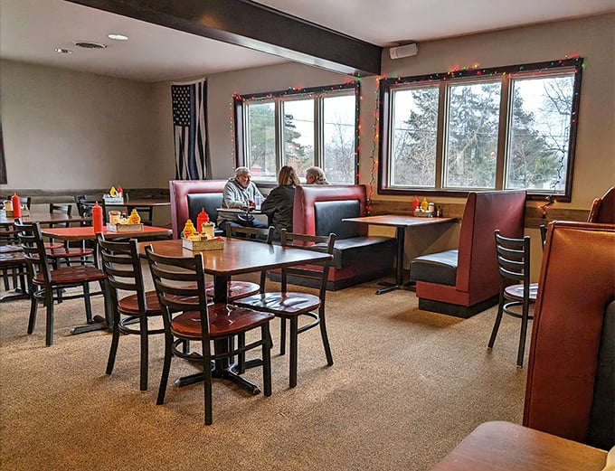 Classic red booths bathed in natural light create that perfect diner atmosphere where conversations flow as freely as the coffee.