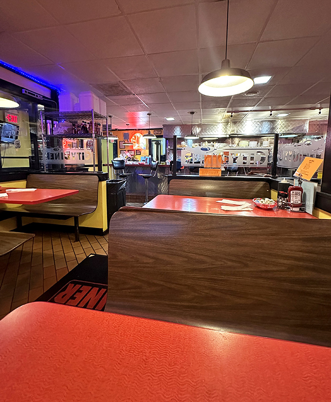 Classic red vinyl booths and warm pendant lighting create that timeless diner atmosphere where conversations flow as freely as the coffee.
