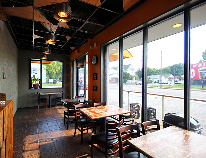 Industrial-chic meets cozy comfort inside, where orange walls and wooden tables create the perfect backdrop for biscuit-based epiphanies.