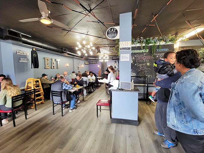 Inside, blue walls and wood floors create a homey vibe where breakfast dreams come true. The "EAT HERE" sign is more command than suggestion.
